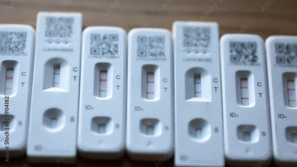 Row of positive Covid-19 antigen rapid home lateral flow tests. Slow ...