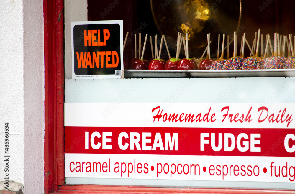 Help wanted sign in a window of a food shop, shows the many jobs open ...