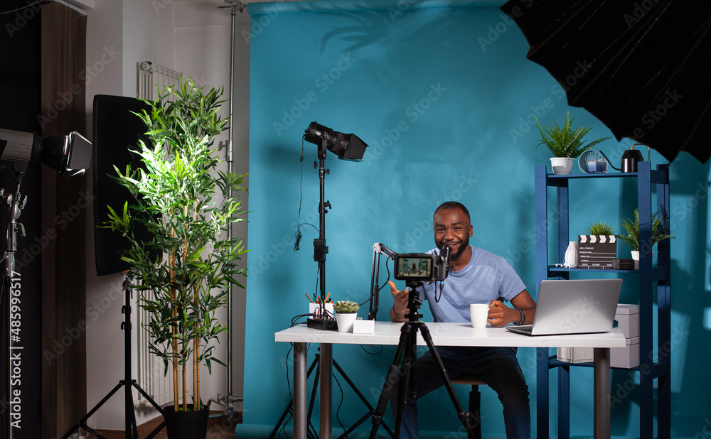 Wide view of vlogging studio setup with smiling vlogger interacting ...