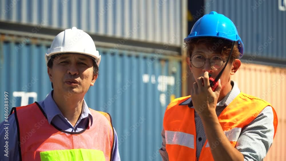 asian senior Foreman and manager talking on the walkie-talkie control ...