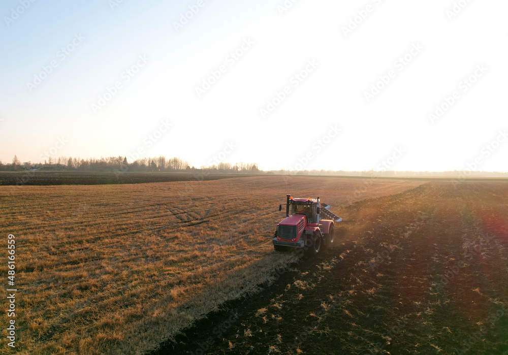Tractor Plowing field on sunset. Red Tractor with Plough on Plowed ...