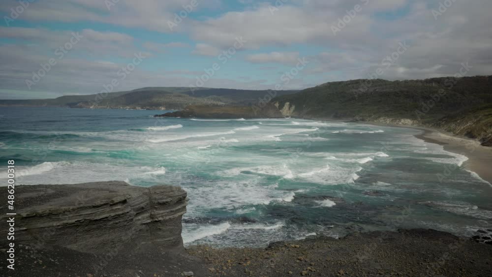 a summer morning view from a cliff of south cape bay beach and surf in ...