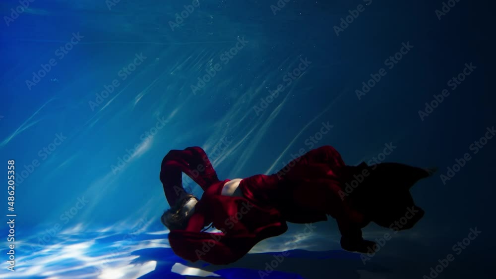 an unusual magical girl who is under water, her hair and dress fabric ...