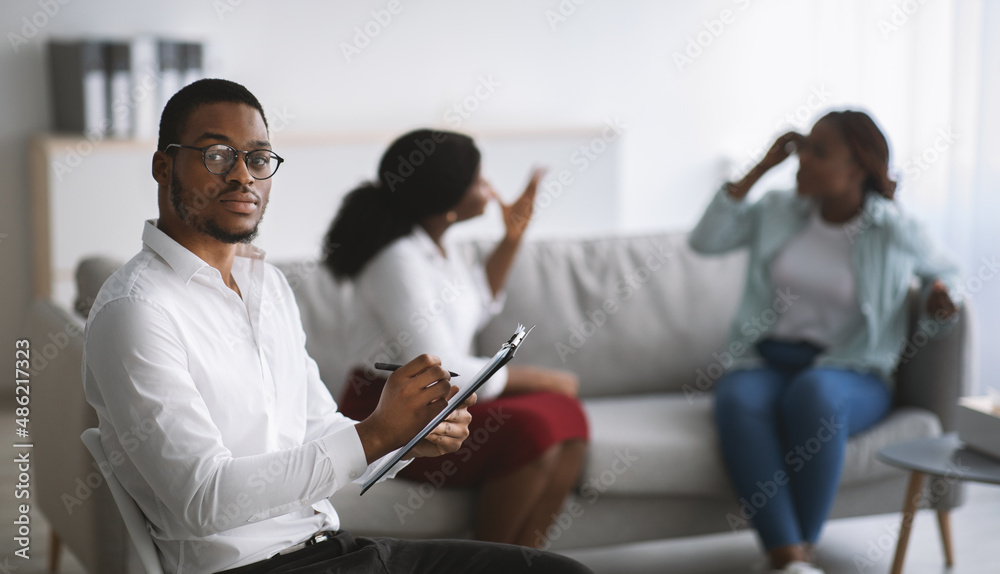 Stressed black male psychologist and angry LGBT lesbian couple fighting ...