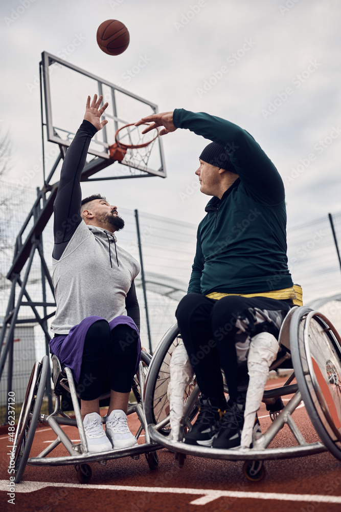Wheelchair-bound basketball player shooting at the hoop during the game ...