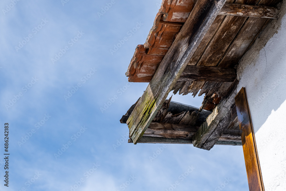 Damaged roof of a house. Broken roof board. Damaged wooden roof. Hole ...
