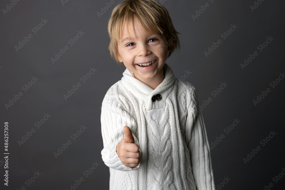Cute little toddler boy, showing YES gesture in sign language on gray ...