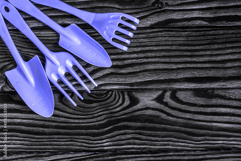Gardening tools concept. Spade, rake and fork on wooden background with ...