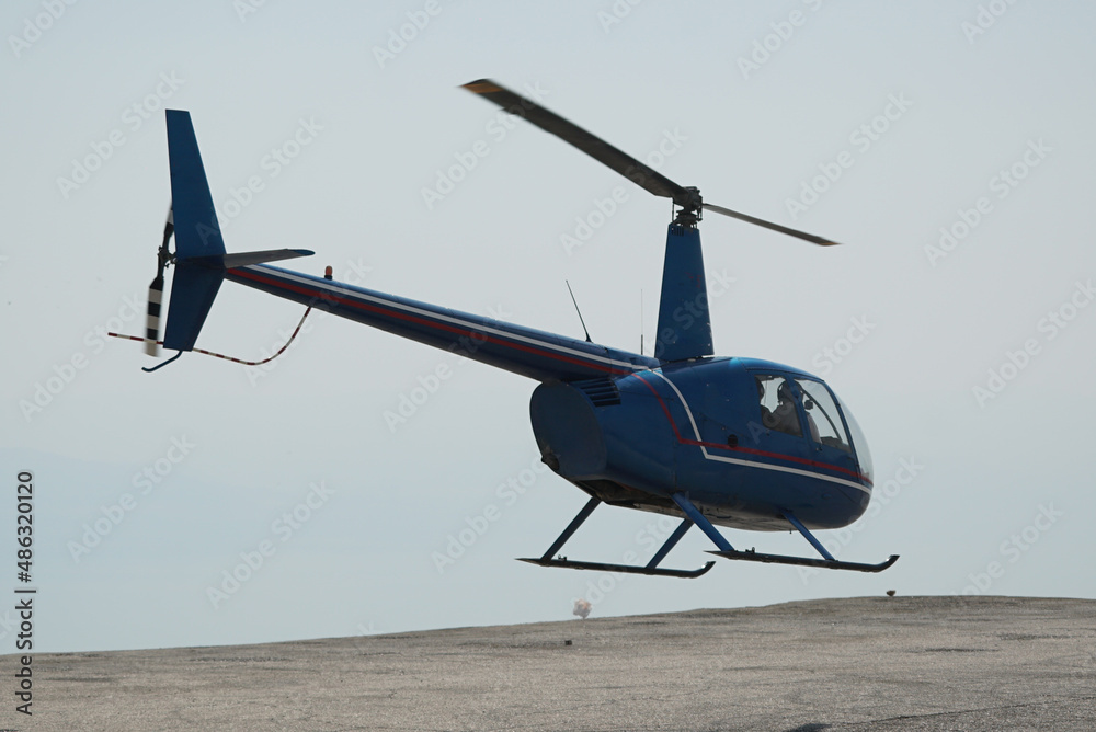 Blue helicopter flying in grey cloudy skies Stock Photo | Adobe Stock