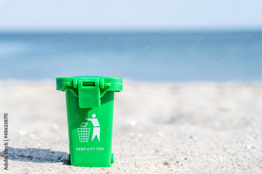 Green colored trash can with paper, plastic, glass and organic waste ...