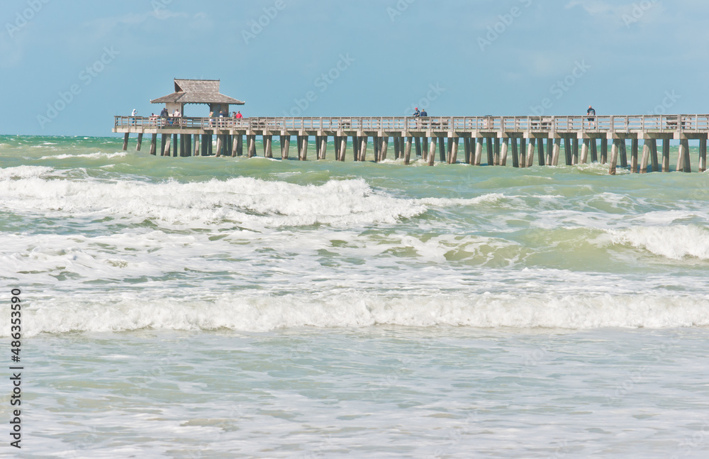 front view, far distance of a tropical, wood pier, jutting out into a ...