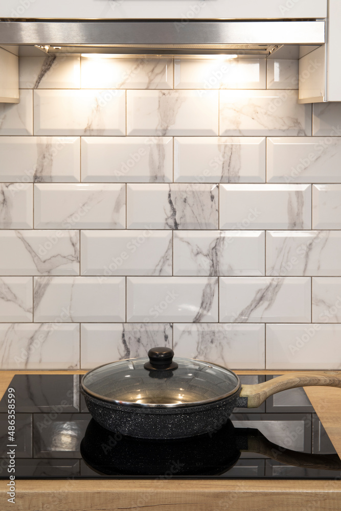 Cook pan at modern kitchen induction cooker hob and wooden counter and ...