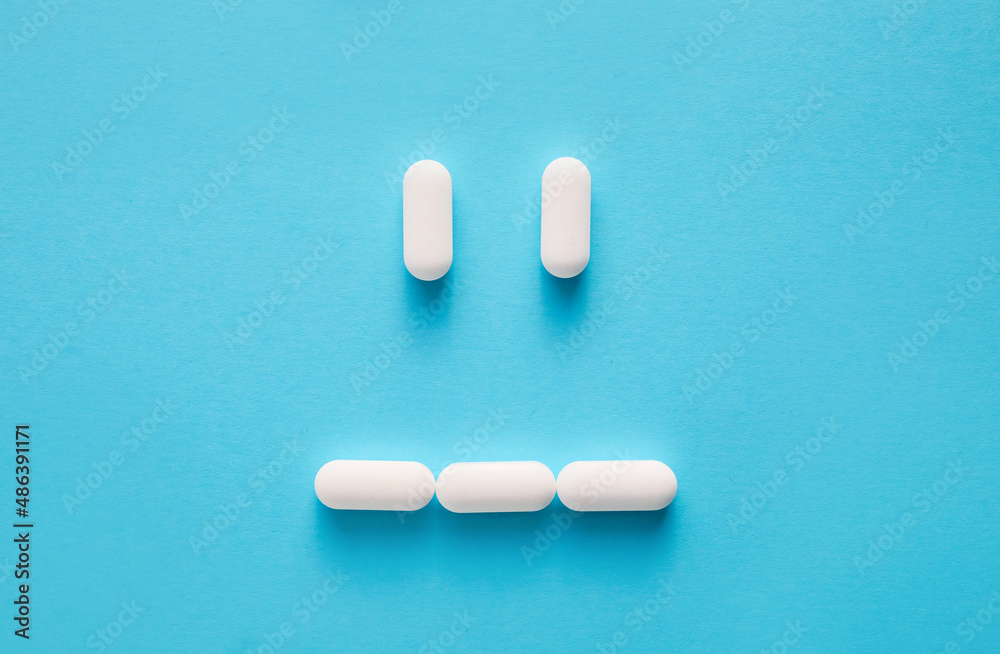 Sad face made of pills on color background Stock Photo | Adobe Stock