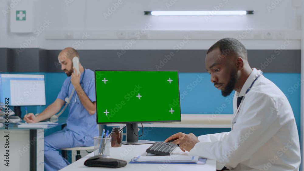 African american doctor sitting at desk in hospital office working at ...