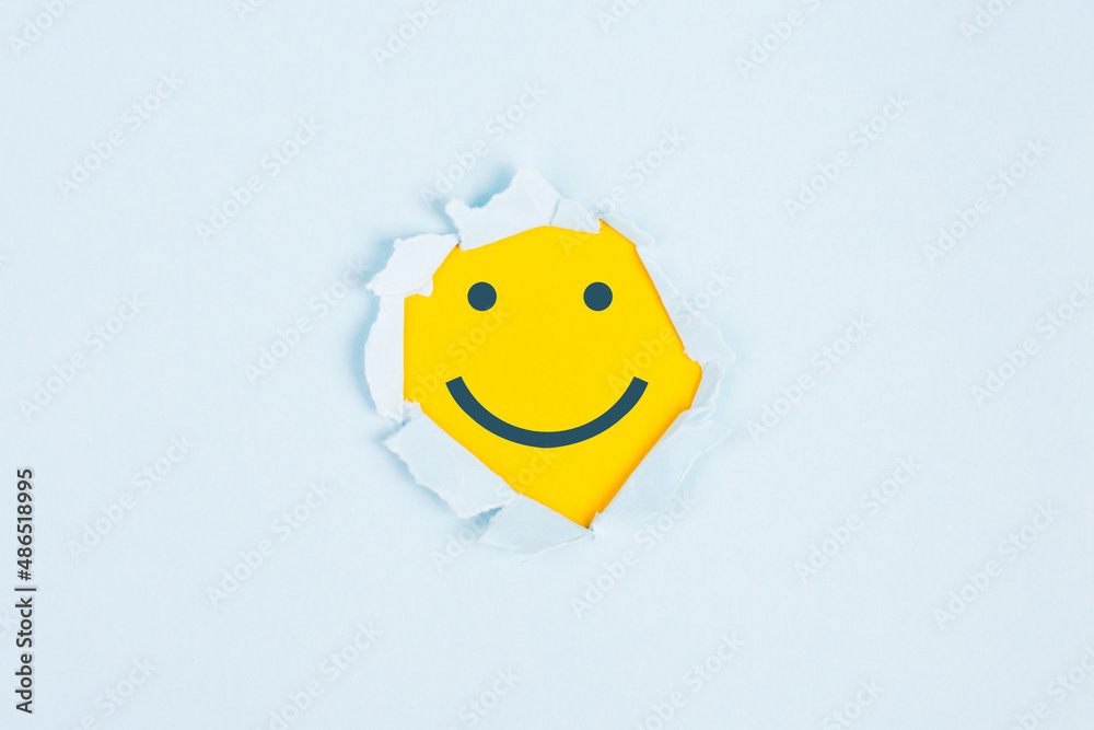 Smiling happy face under a torn paper, positive emotions, good customer ...