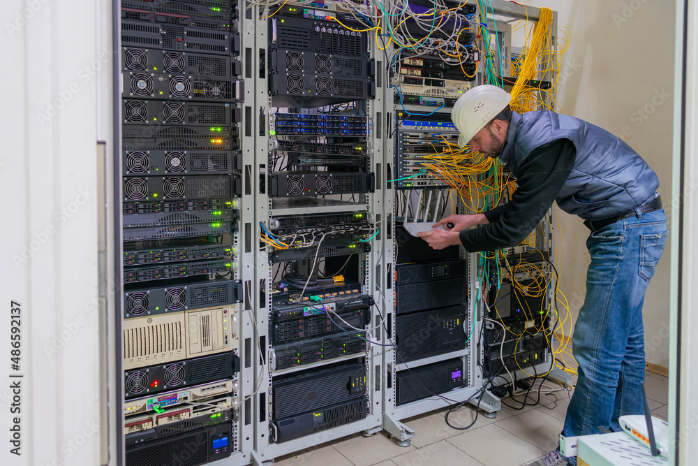 A technician works in a server room. Support for the network ...