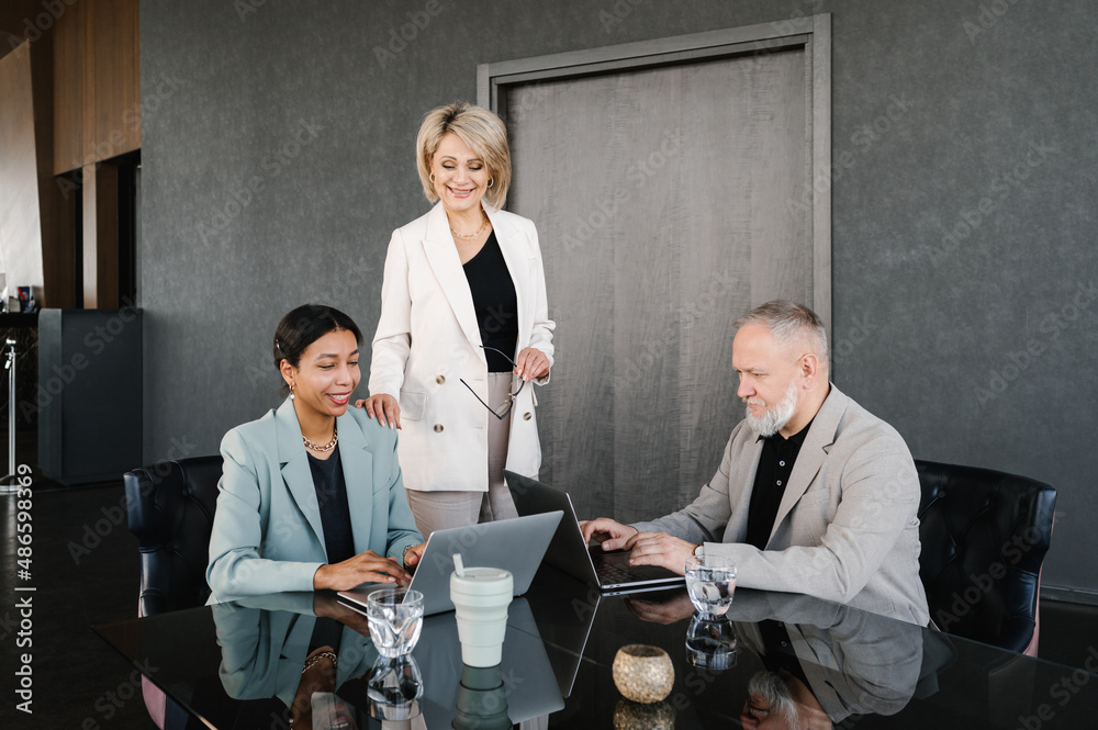 Businesswoman controlling work of diverse employees Stock Photo | Adobe ...