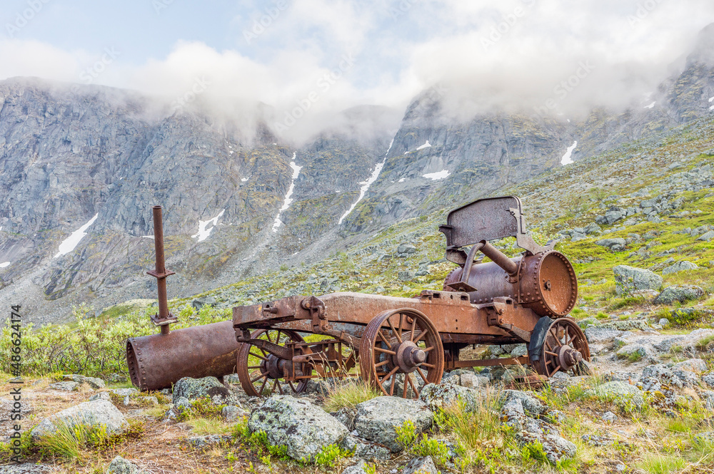Old rusty iron steam machine left on the mountain slope near an ...