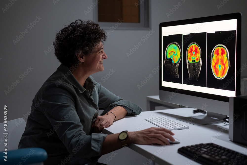 Female analyzing brain scan on computer Stock Photo | Adobe Stock