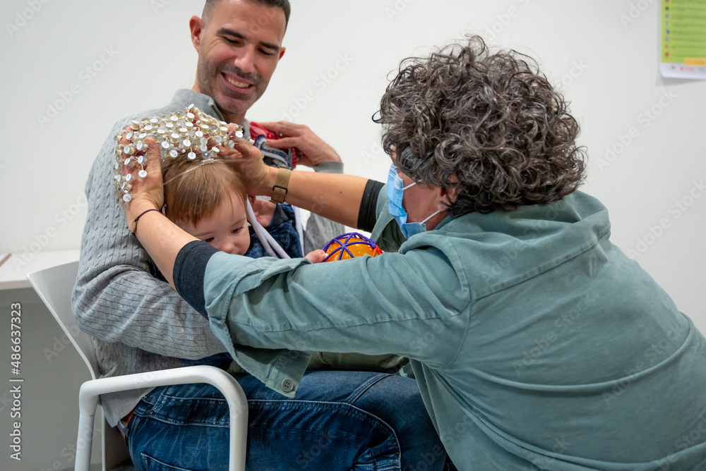 Medical personnel preparing crying child for EEG test Stock Photo ...