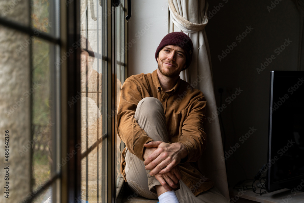 Portrait of smiley man sitting by the window at home Stock Photo ...