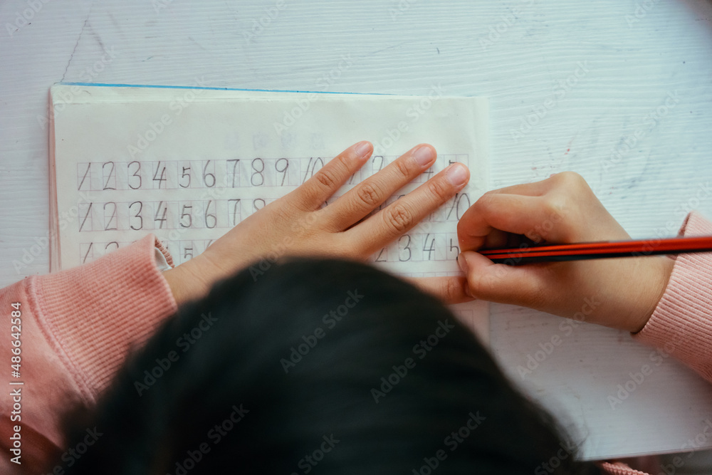 Child girl writing math numbers Stock Photo | Adobe Stock