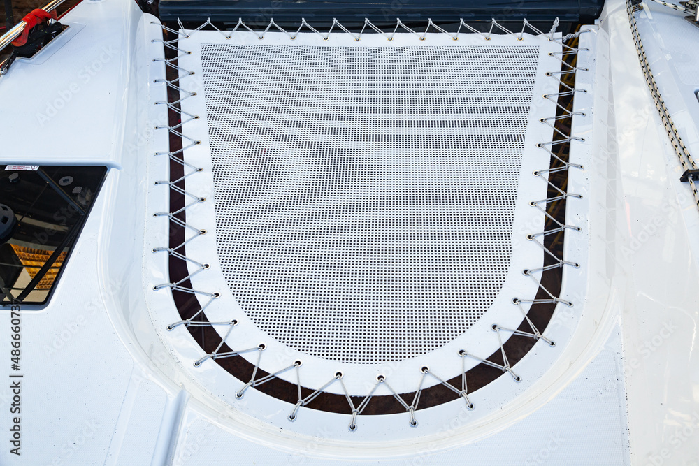 Part of a stretched white net with ropes threaded into loops on the ...