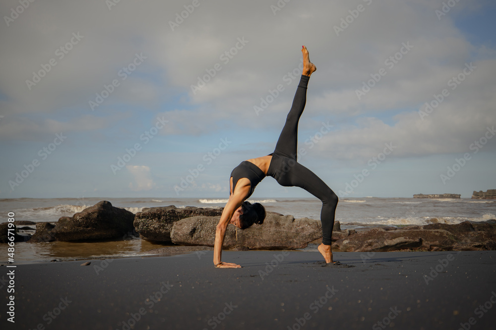 Bali yoga. Slim Asian woman practicing Eka Pada Chakrasana, One Legged ...
