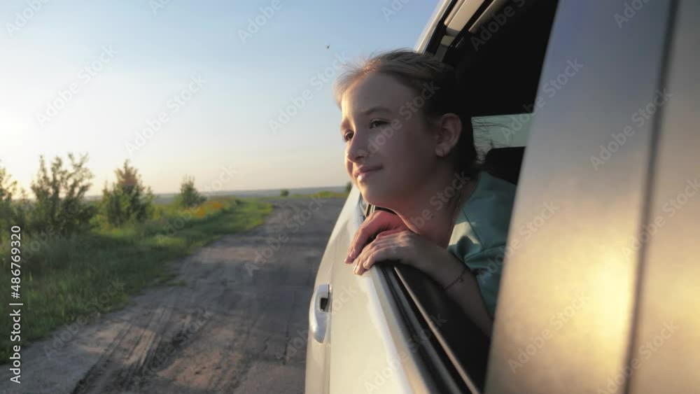 Happy family travel. Little girl leaning out of car window waving hand ...