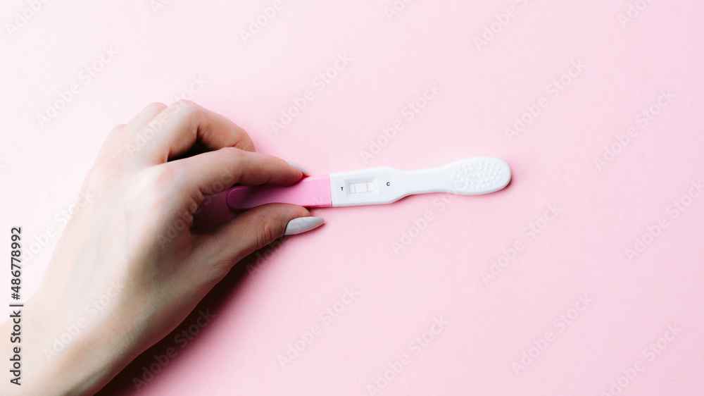 Pregnancy test kit. Female hand hold positive pregnant test with silk ...