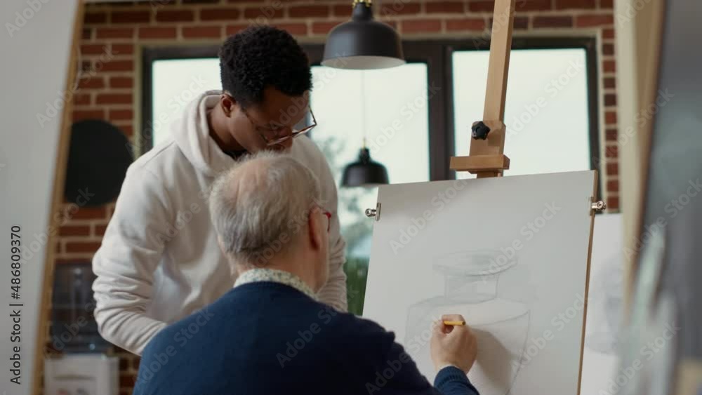 Male artist explaining drawing technique to elder woman attending ...
