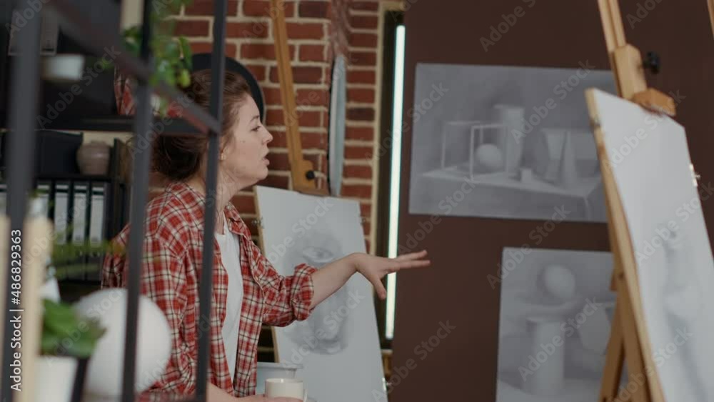 Female artist using vase model to explain drawing technique, teaching ...