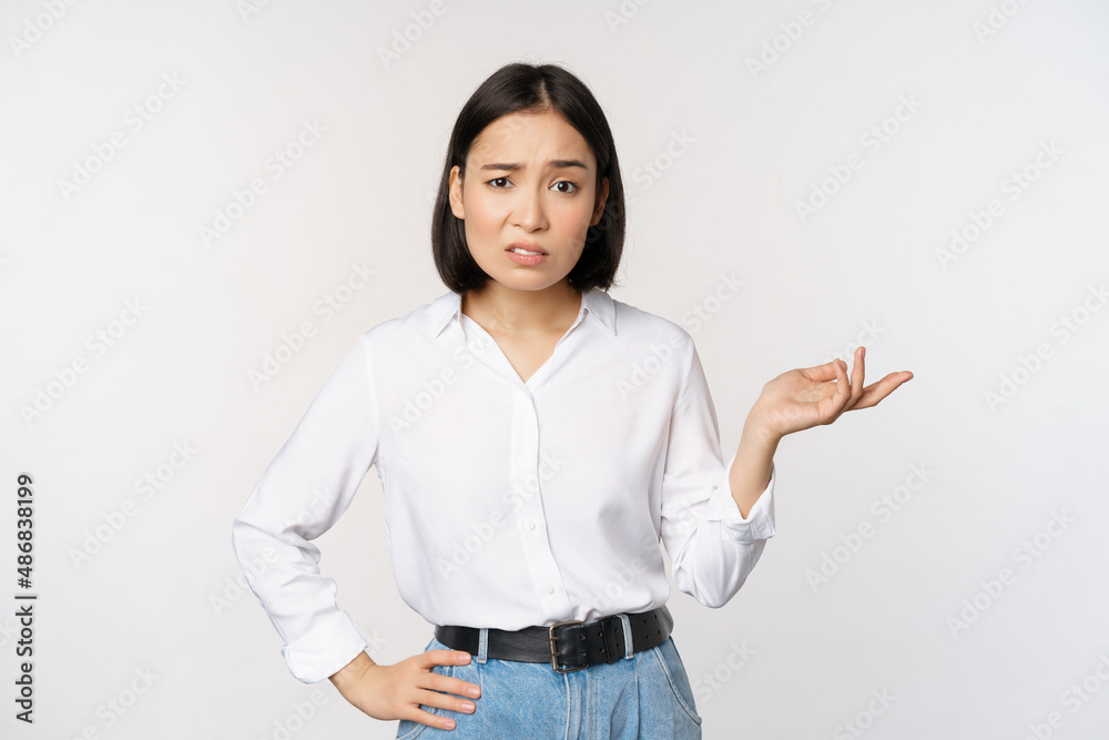 Portrait of confused asian woman asking so what, whats your problem ...