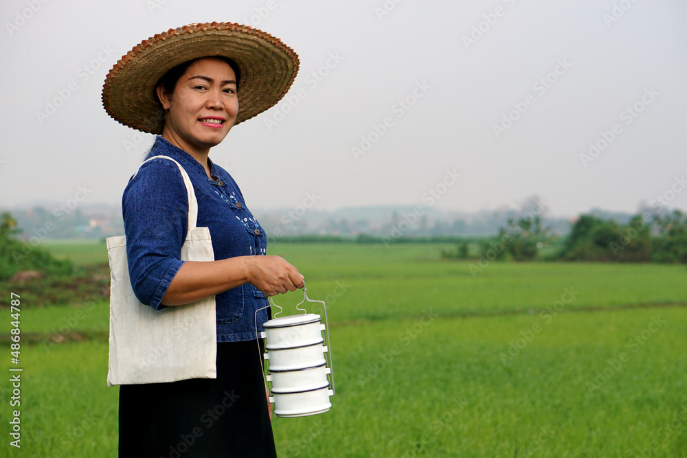 Asian female farmer hold tiffin rice box for lunch and cotton bag ...