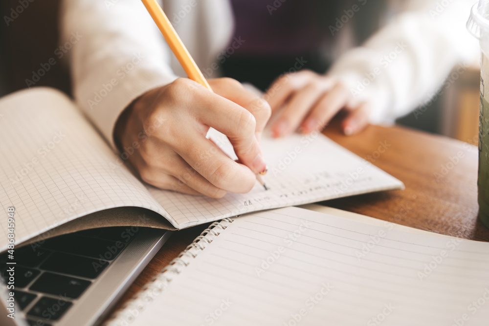 Young adult women hand writing note for study and work online at cafe ...