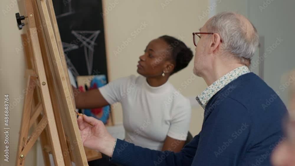 Multiethnic team of woman and man drawing on canvas together in ...