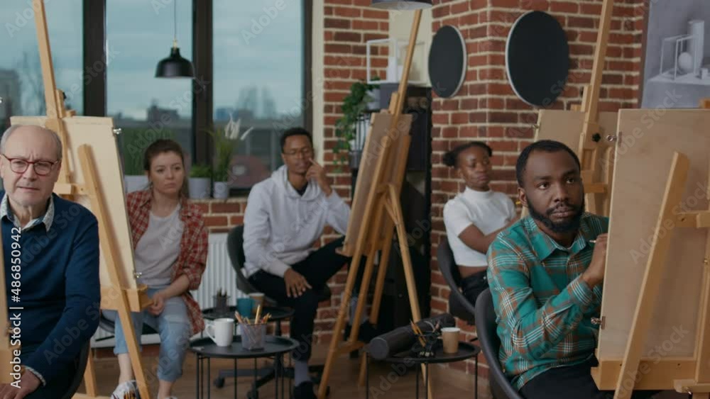 Video Stock Senior teacher explaining drawing technique to diverse team ...