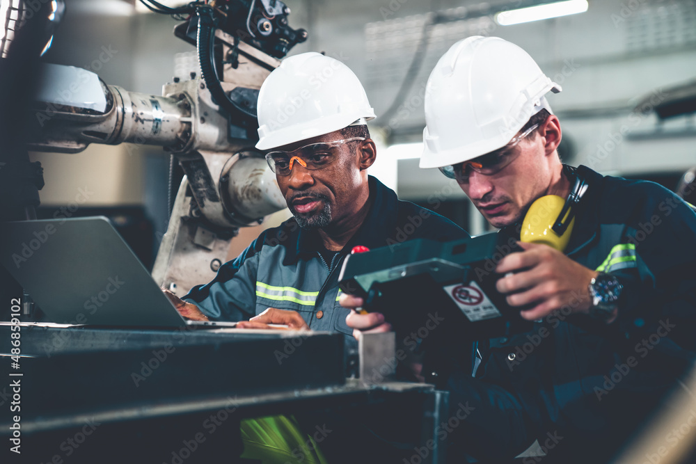 Factory workers working with adept robotic arm in a workshop . Industry ...