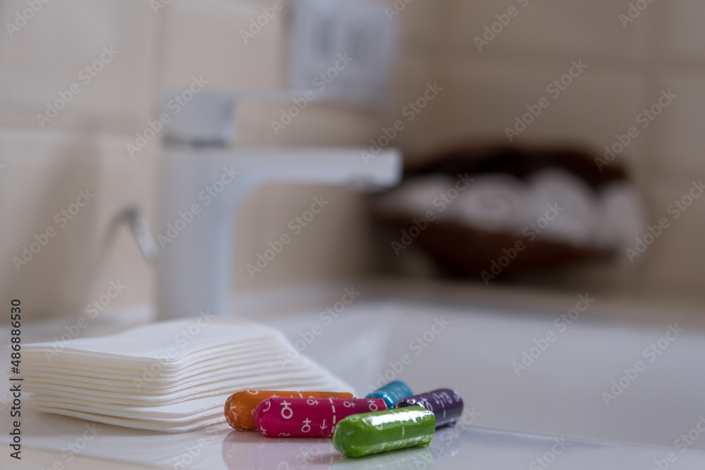 Female sanitary pads and medical female tampons on the bathroom table ...