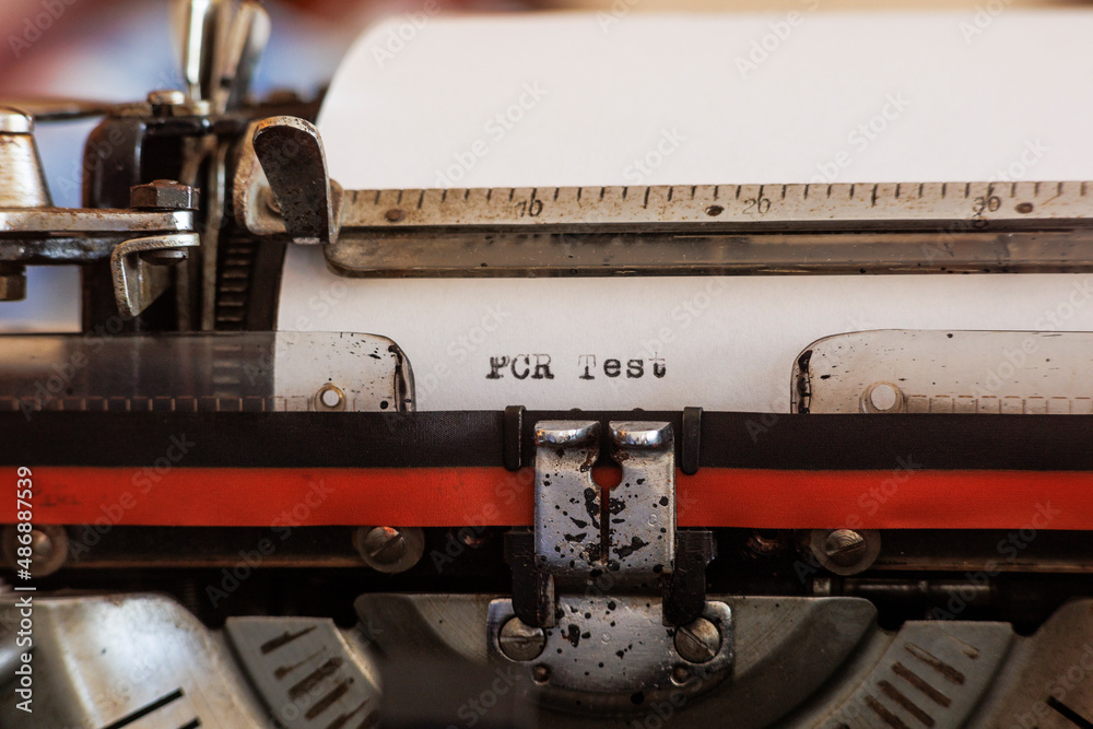 The German word PCR Test written in black ink on a white sheet of paper ...
