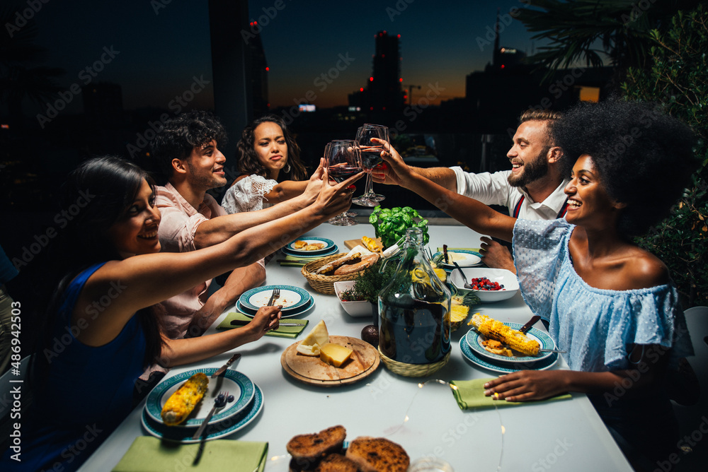 Group of friends having fun on the rooftop of a beautiful penthouse ...