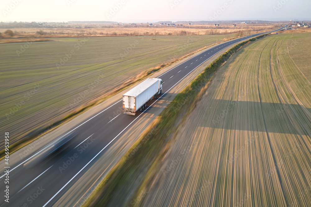 Aerial view of blurred fast moving semi-truck with cargo trailer ...