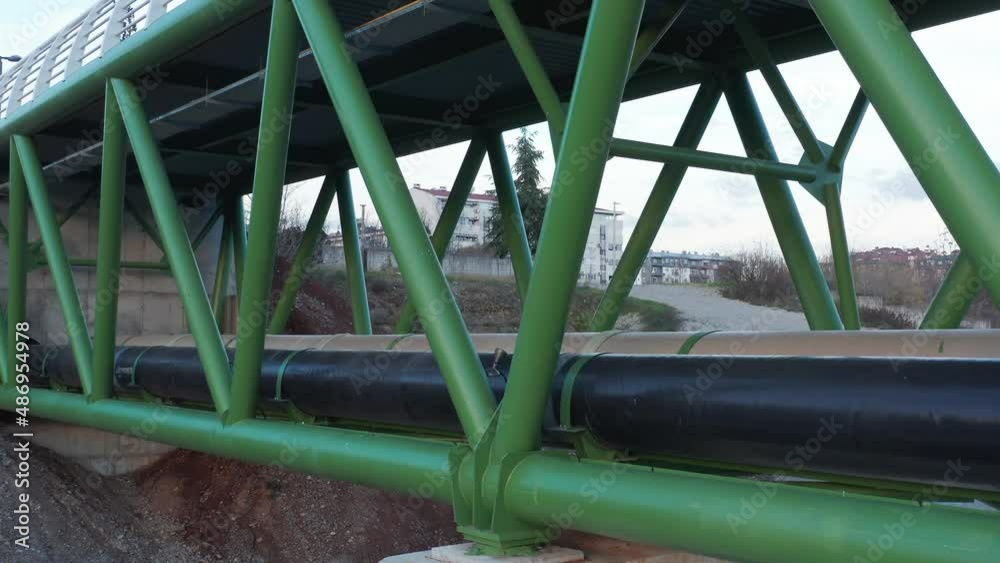 Vidéo Stock Green metal bridge carrying oil, gas or sewer pipelines ...