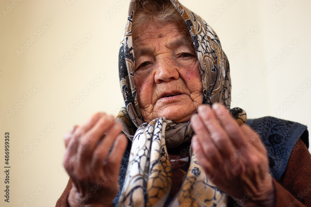 Elderly muslim woman praying, worship Allah for help and hope. Eid ...