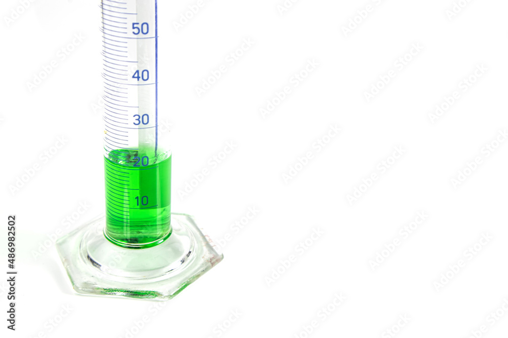 Measuring lab glass with green liquid. Laboratory graduated cylinder ...