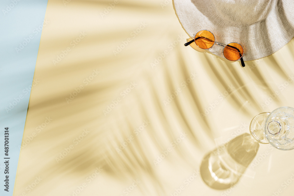 Summer beach rest concept background with sun hat, glass of water with ...
