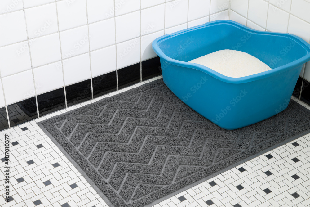 Black cat litter rubber mat on vintage bathroom floor with blue litter ...