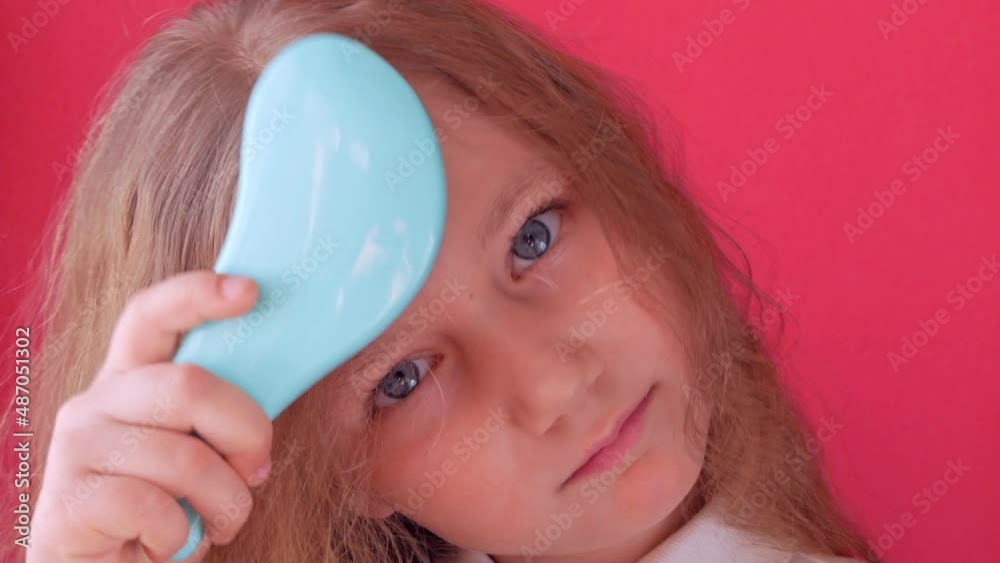 Girl combing dry tangled wavy hair with brush in hand close-up 4k ...