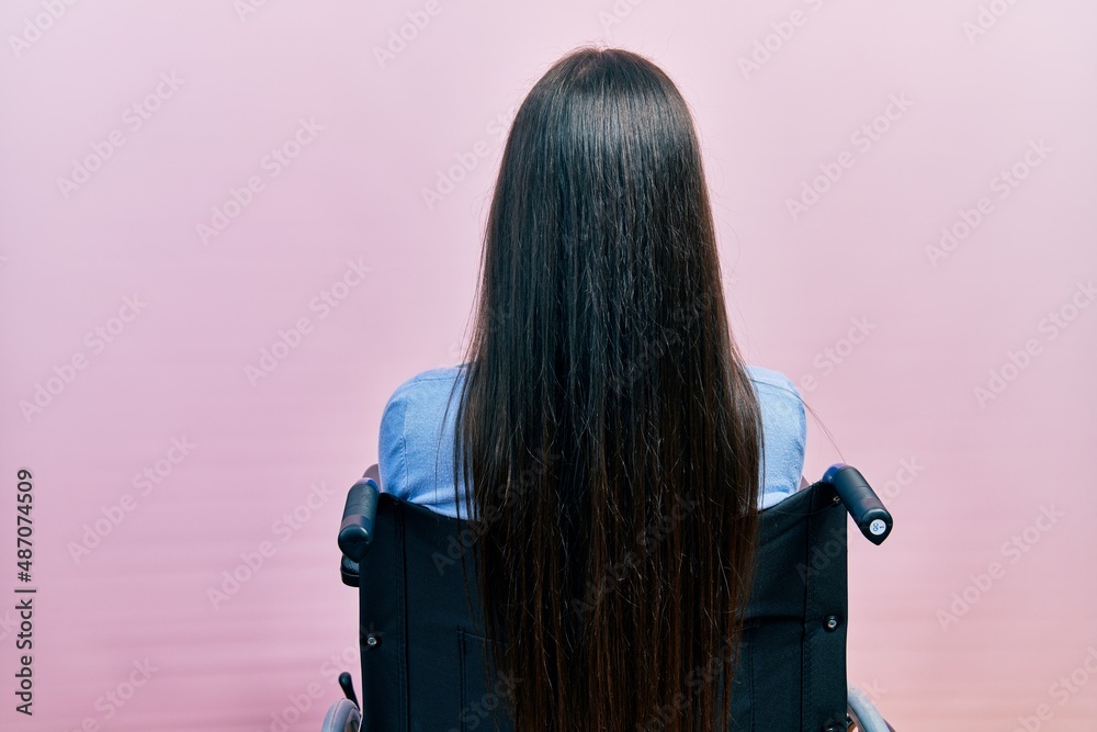 Beautiful woman with blue eyes sitting on wheelchair standing backwards ...