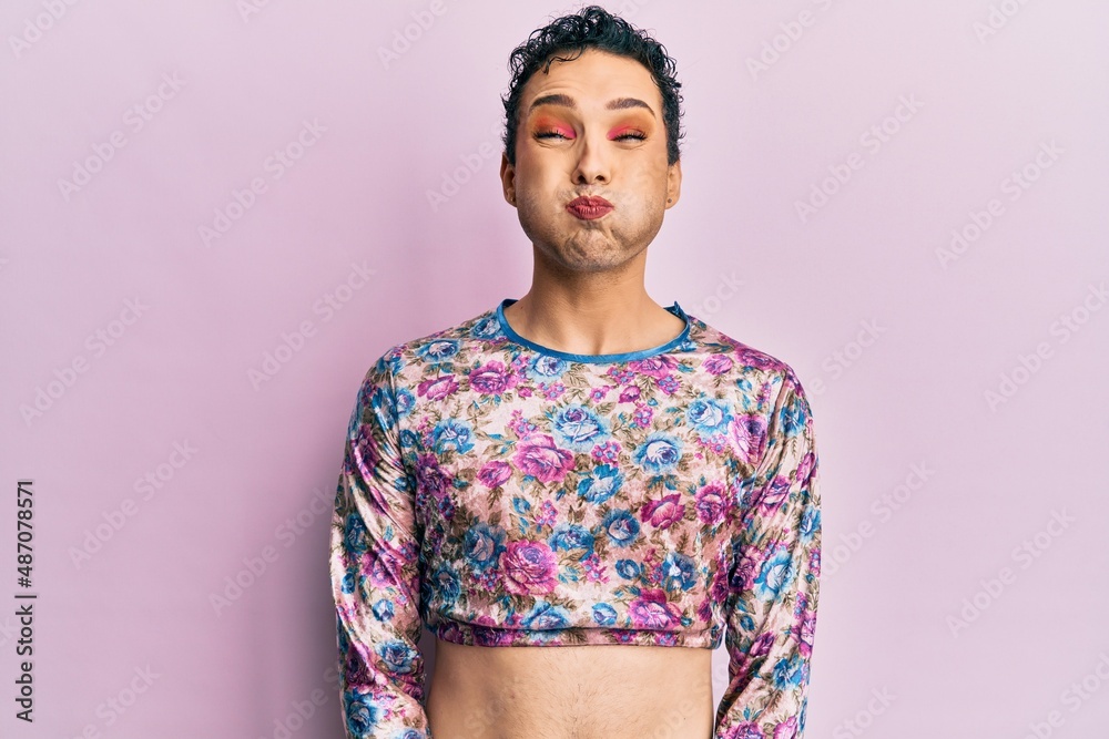 Handsome man wearing make up wearing fashion clothes puffing cheeks ...
